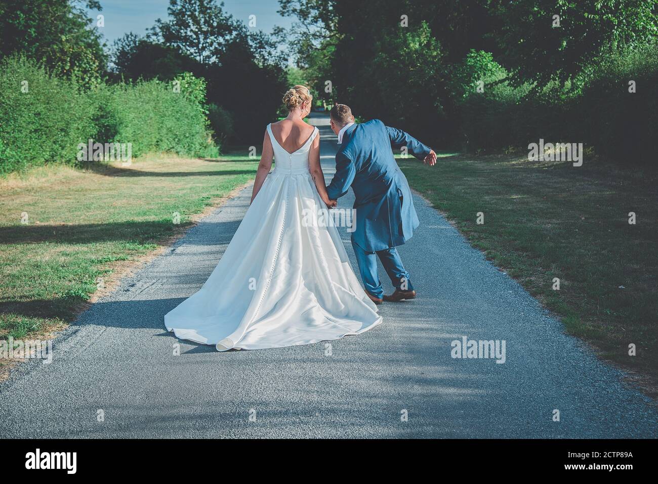 Couple walking away down the road at their wedding in Norfolk Stock ...