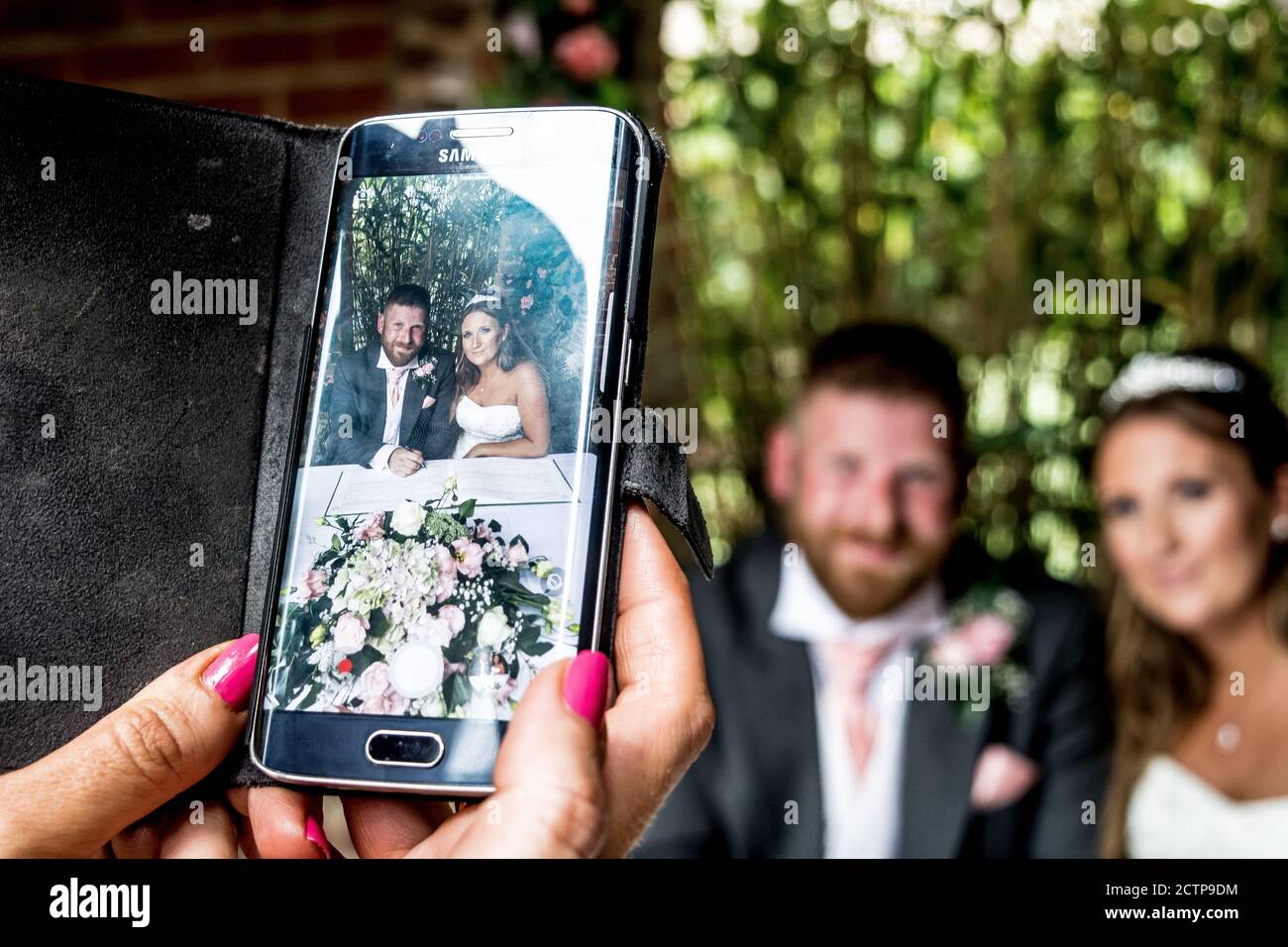 Bride & Groom through the lens of a smartphone Stock Photo - Alamy