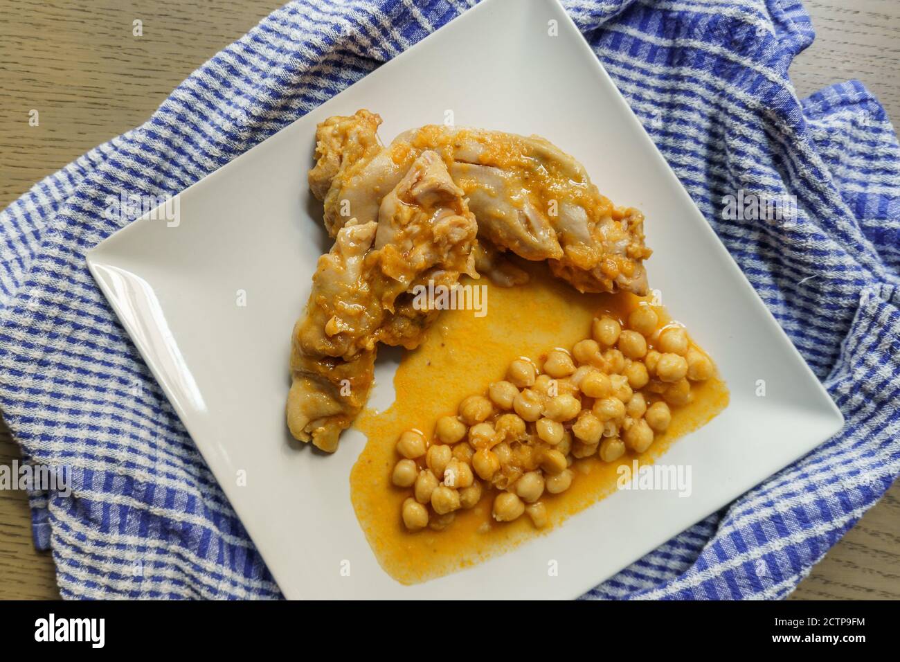 Typical Spanish dish, braised pork legs with chickpeas and cherry ...