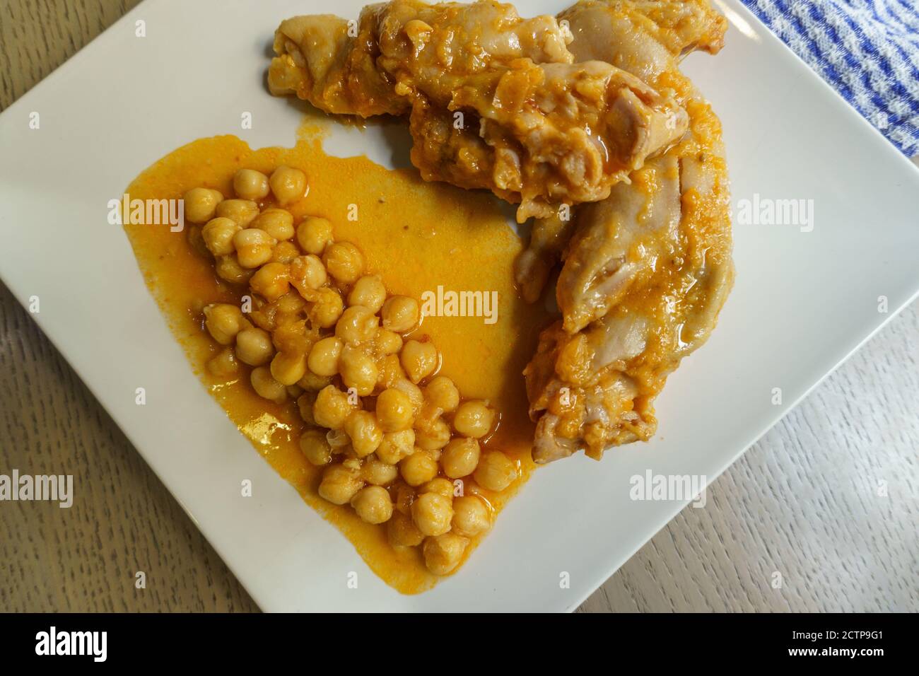 Typical Spanish dish, braised pork legs with chickpeas and cherry ...