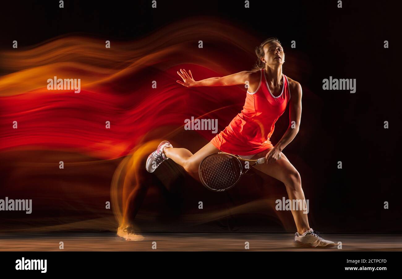 Champion. Professional female tennis player training isolated on black ...