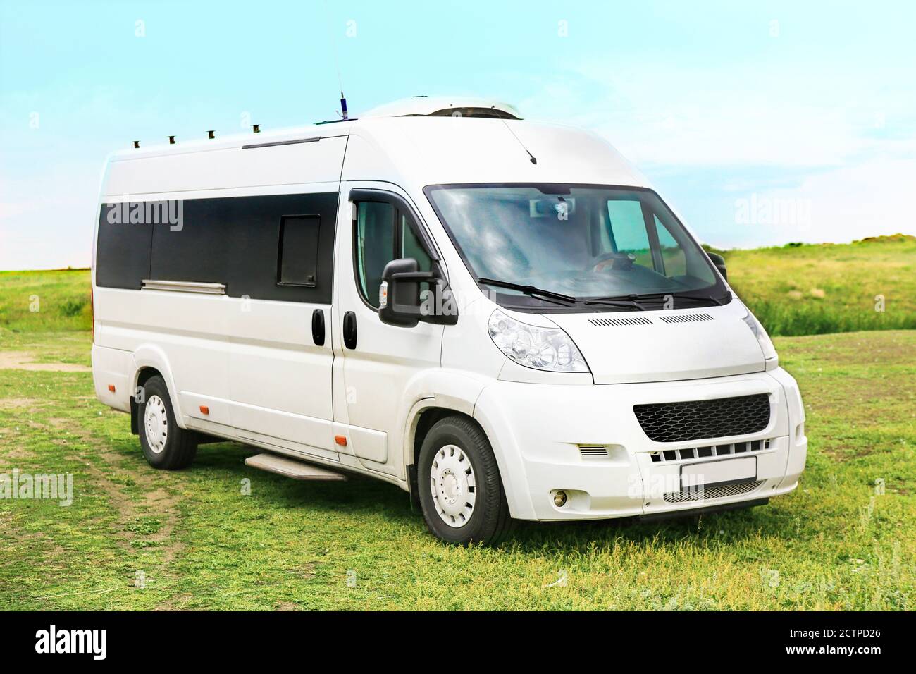 white minibus on in the field against the sky Stock Photo - Alamy