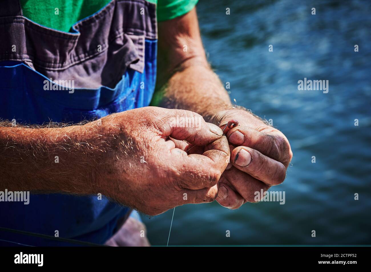 Scene while fishing on a river while attaching the bait Stock Photo - Alamy