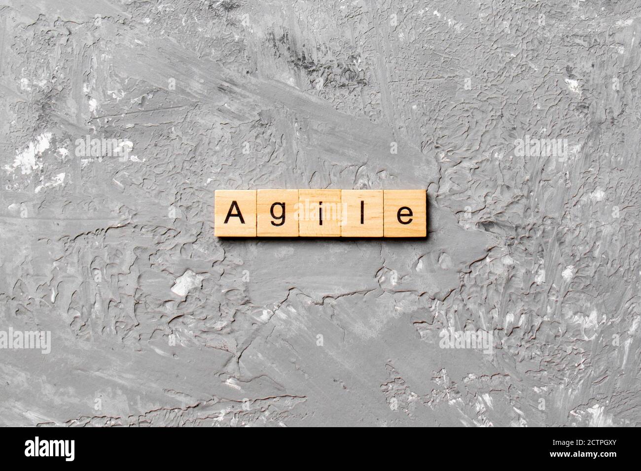 Agile word written on wood block. Agile text on cement table for your ...