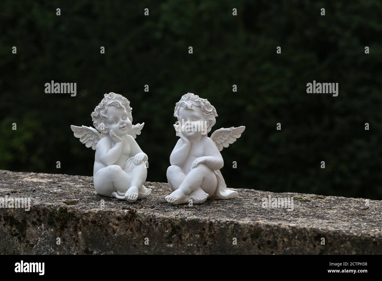Closeup shot of a miniature of two angels on a stone wall in a ...