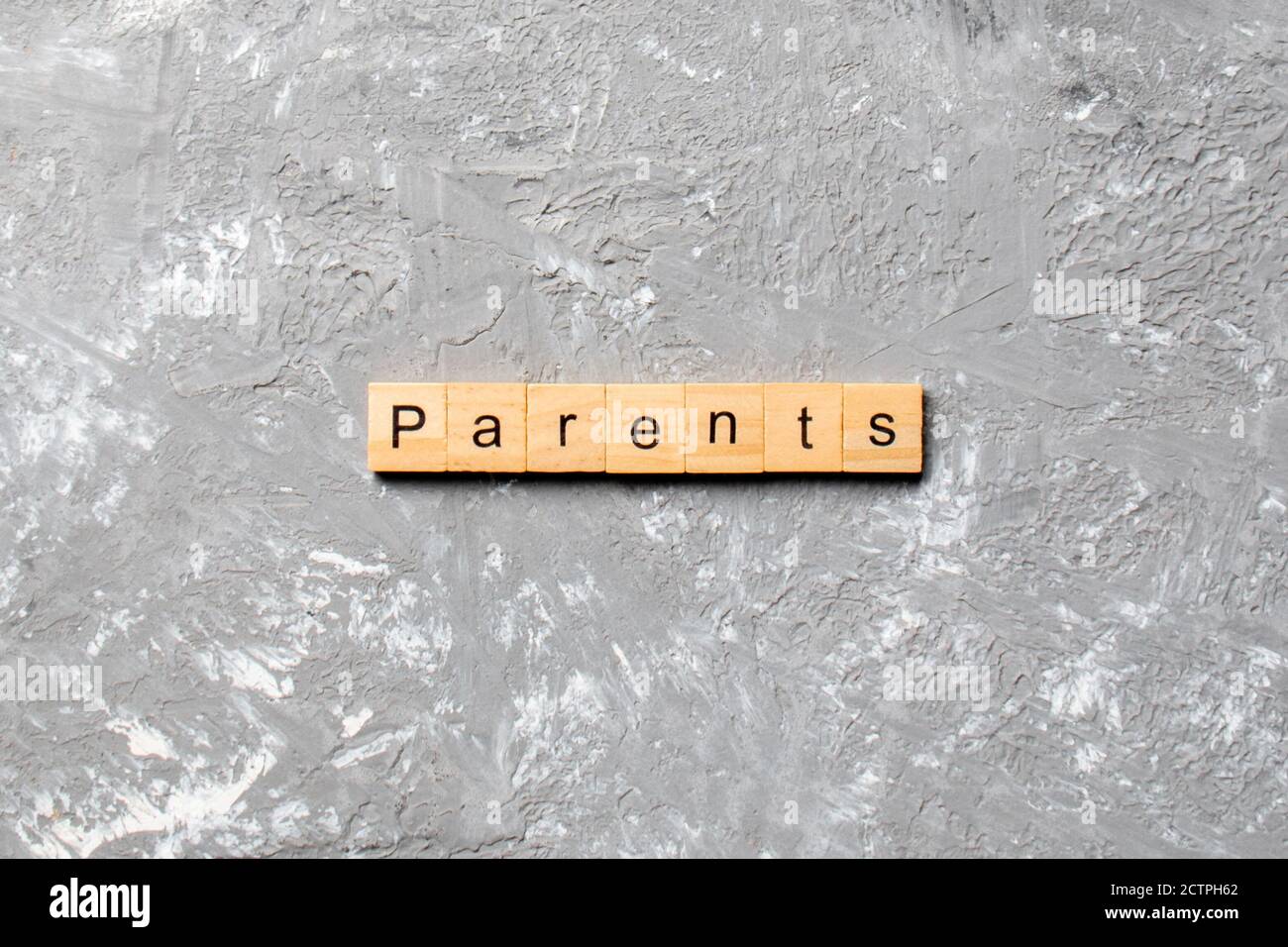 Parents word written on wood block. Parents text on cement table for ...