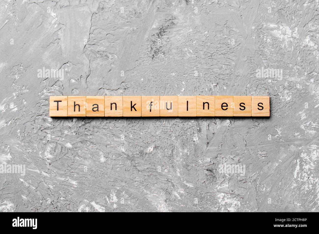 Thankfulness word written on wood block. Thankfulness text on cement ...