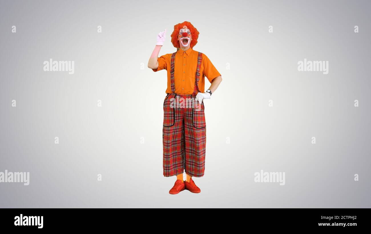 Clown pointing a finger up having and idea and thinking on gradi Stock ...