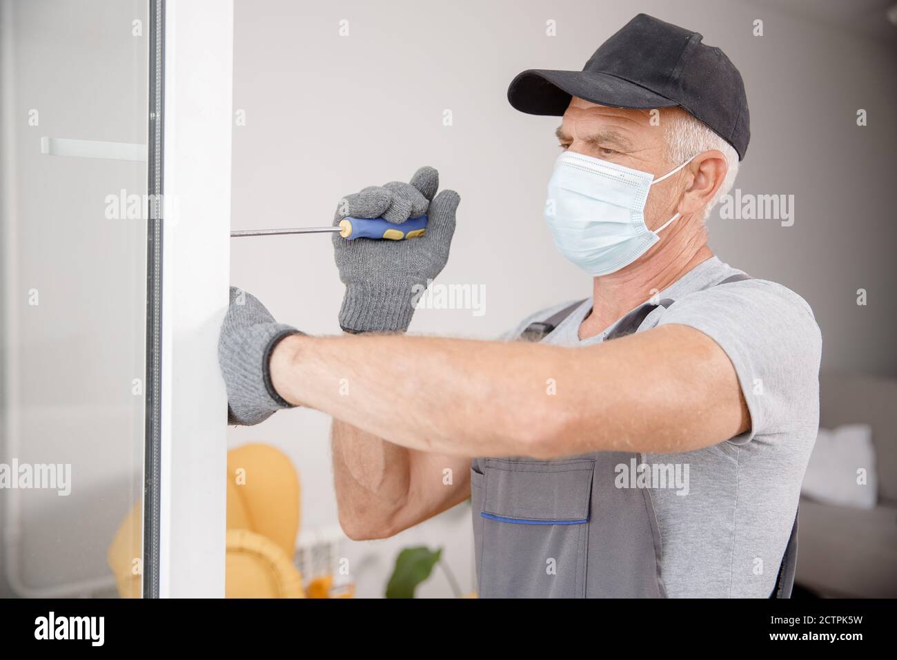 Worker man installs plastic windows and doors with double-glazed white ...