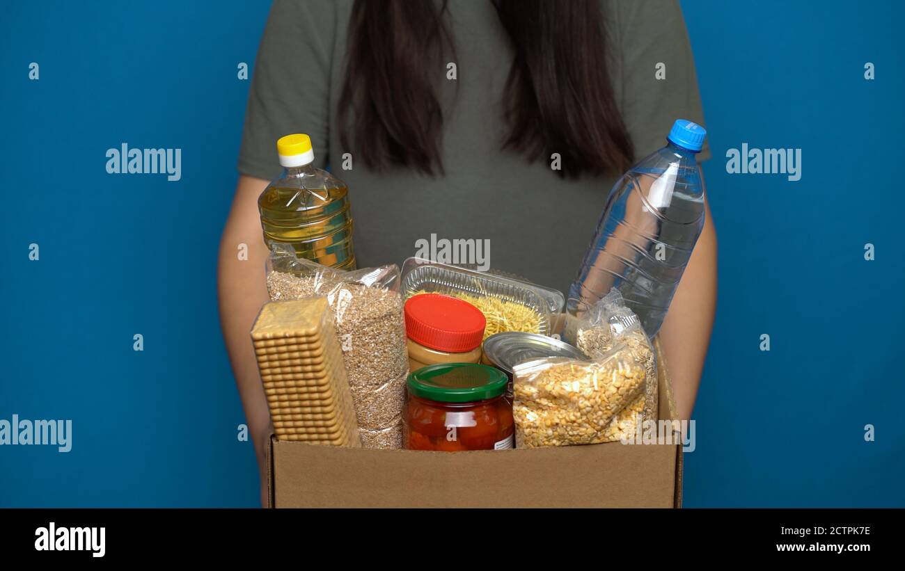 Volunteer putting food in a donation box Stock Photo - Alamy