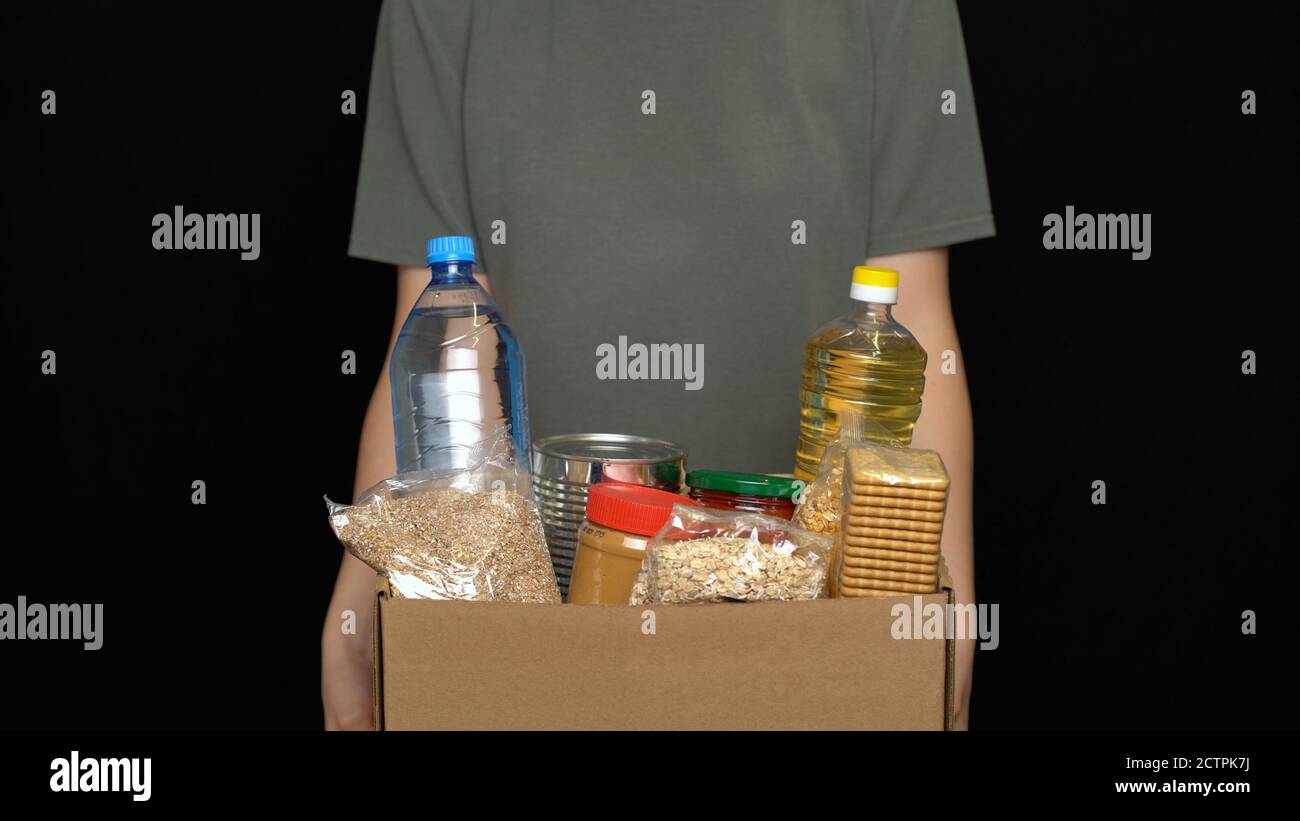 Volunteer putting food in a donation box Stock Photo - Alamy