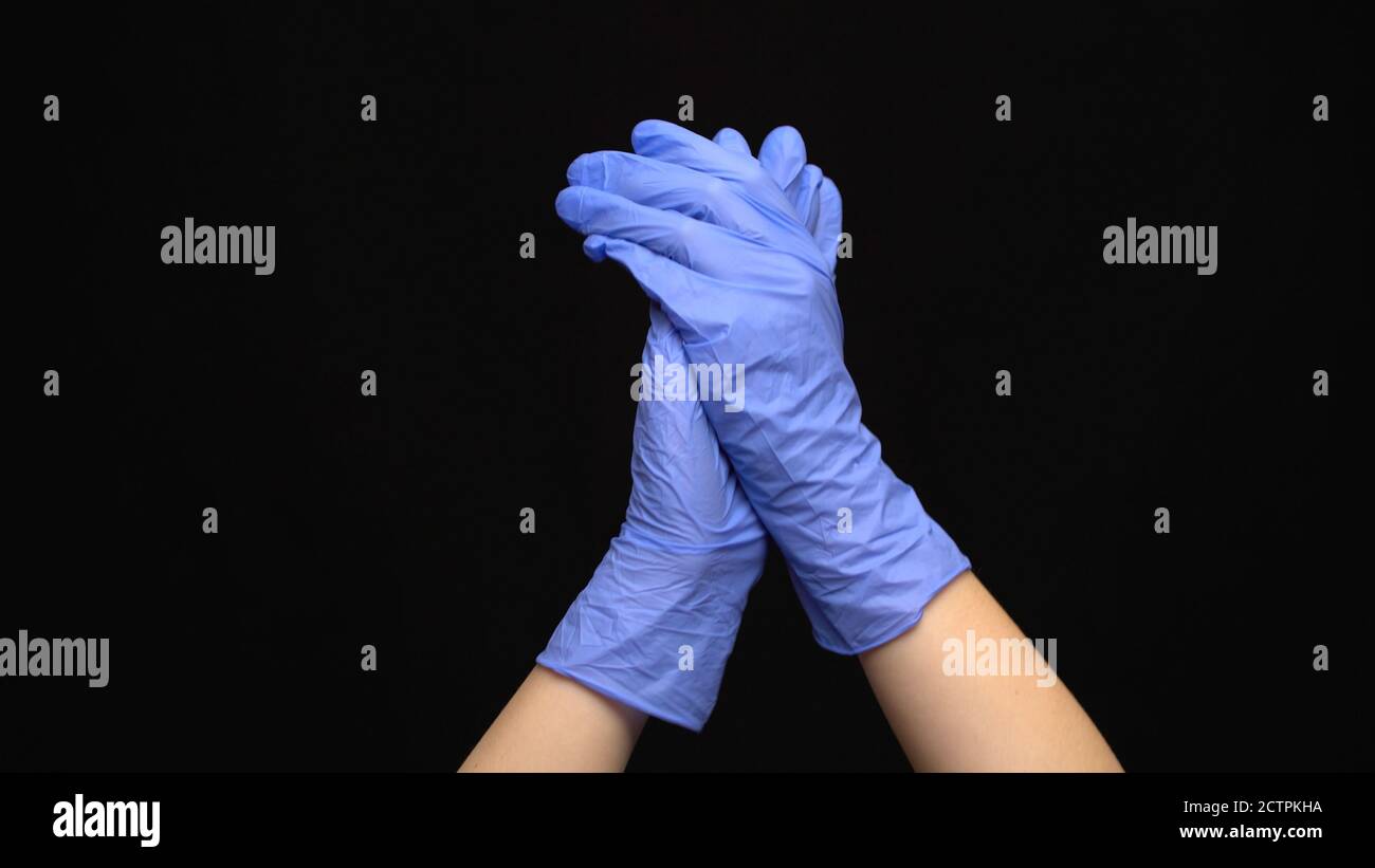 Medical hands with blue gloves clapping on black background Stock Photo ...