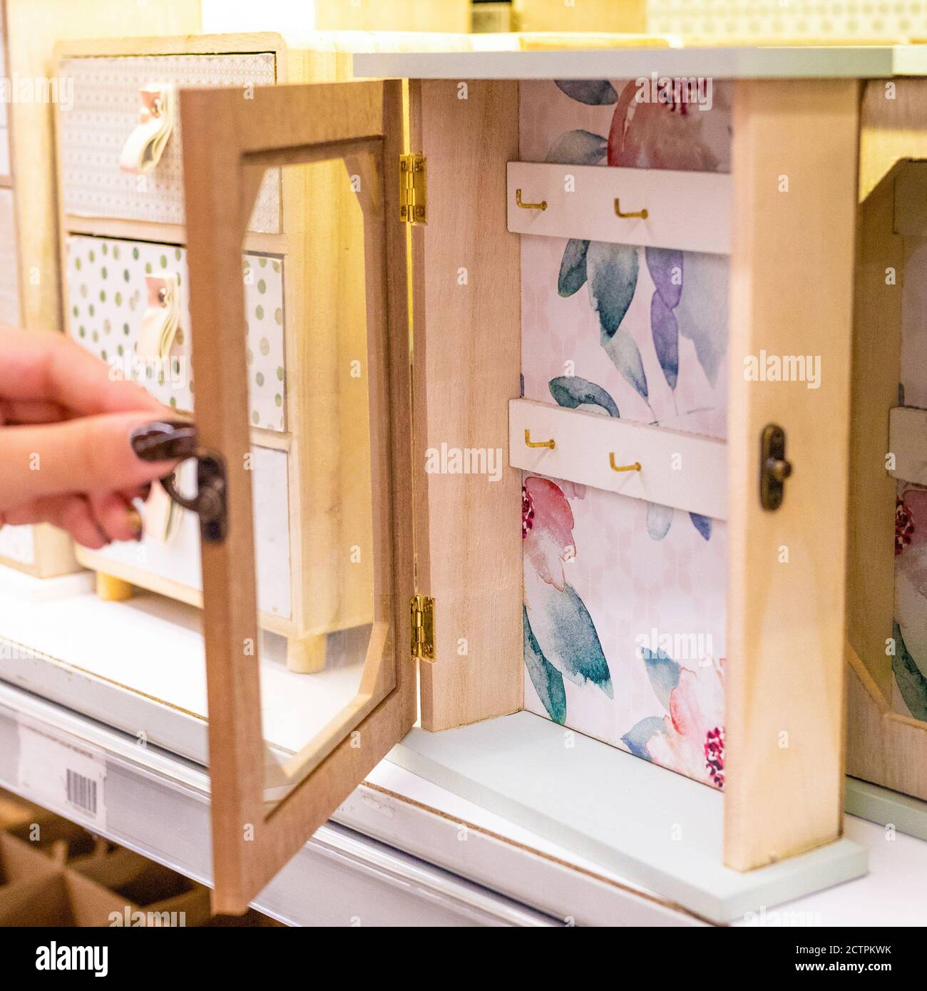 Woman opening wooden key hanger box Stock Photo - Alamy