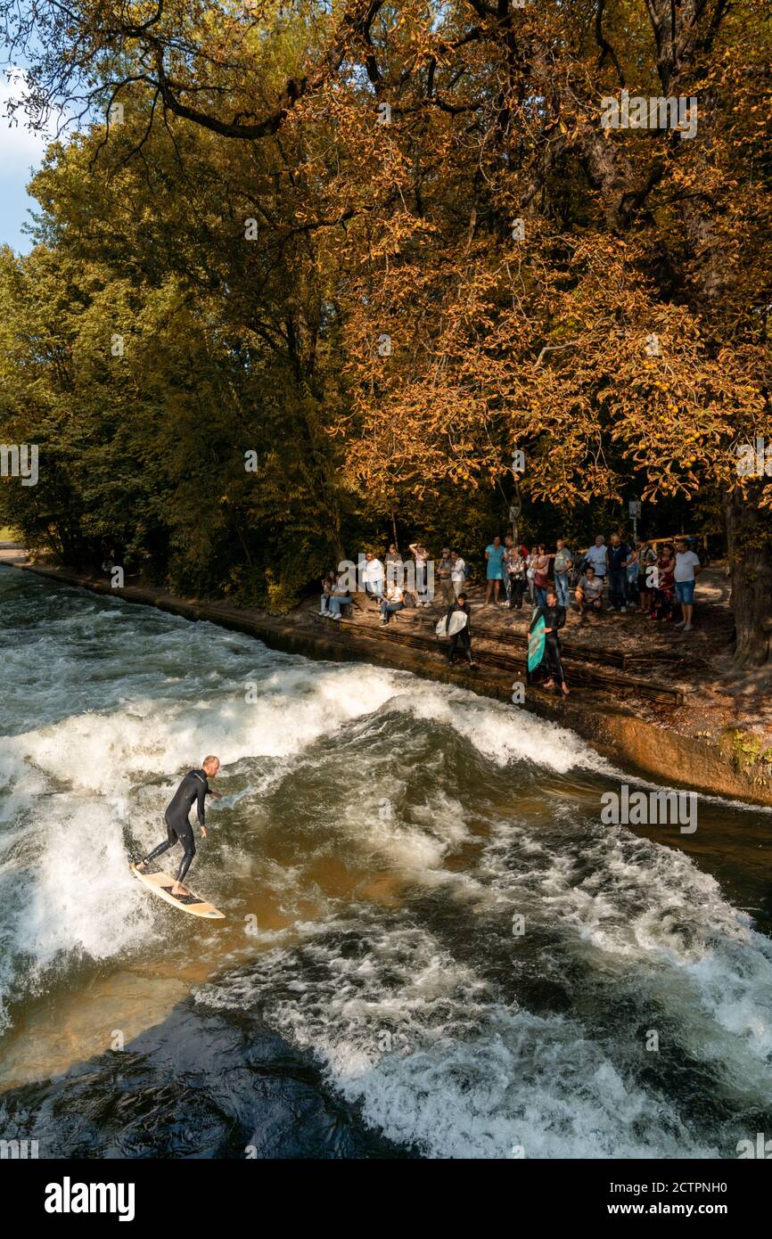 man surfing the standing wave on the Eisbach creek in downtown Munich ...