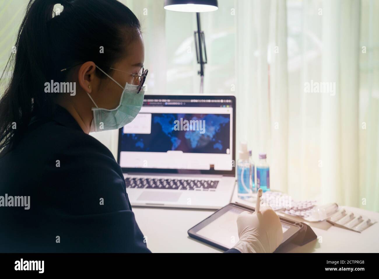Female Doctor's working on laptop computer, writing prescription ...