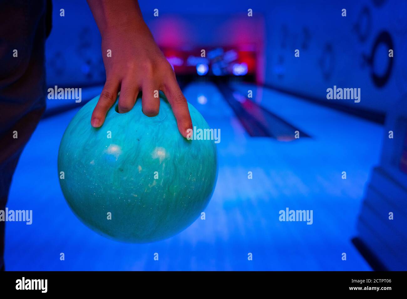 Men's hand holding a blue bowling ball ready to throw Stock Photo - Alamy