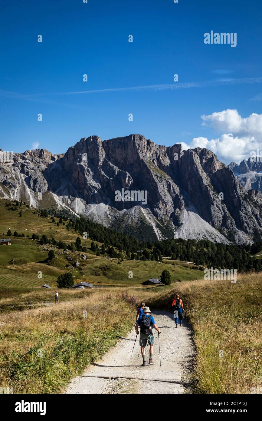 Walkers make their way along a mountain track with spectacular views of ...