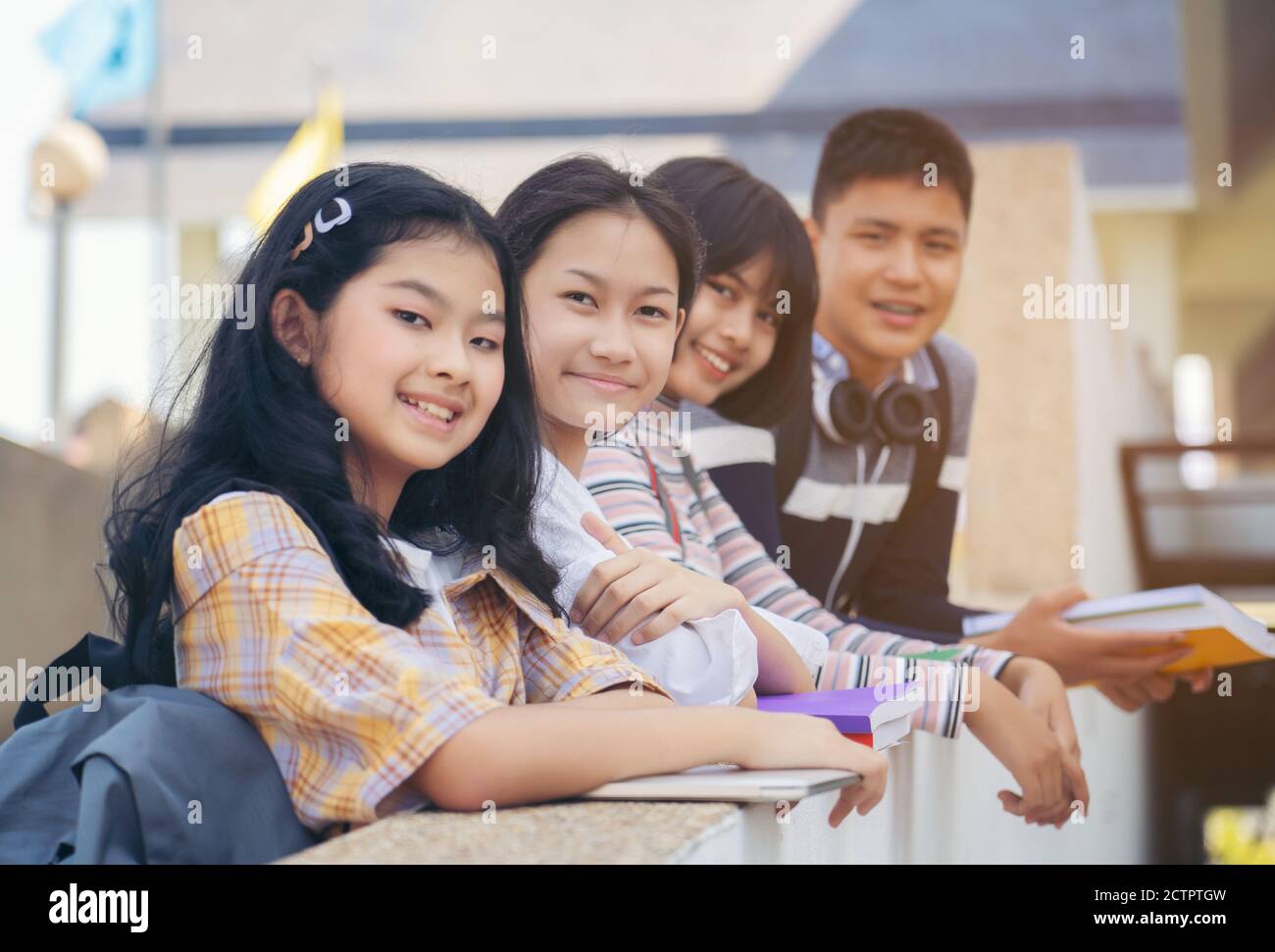 Group of students standing together over wall walkway Stock Photo - Alamy