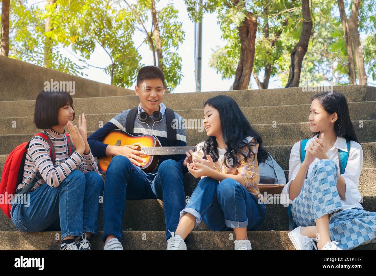 Group of child student playing guitar and singing songs together in ...