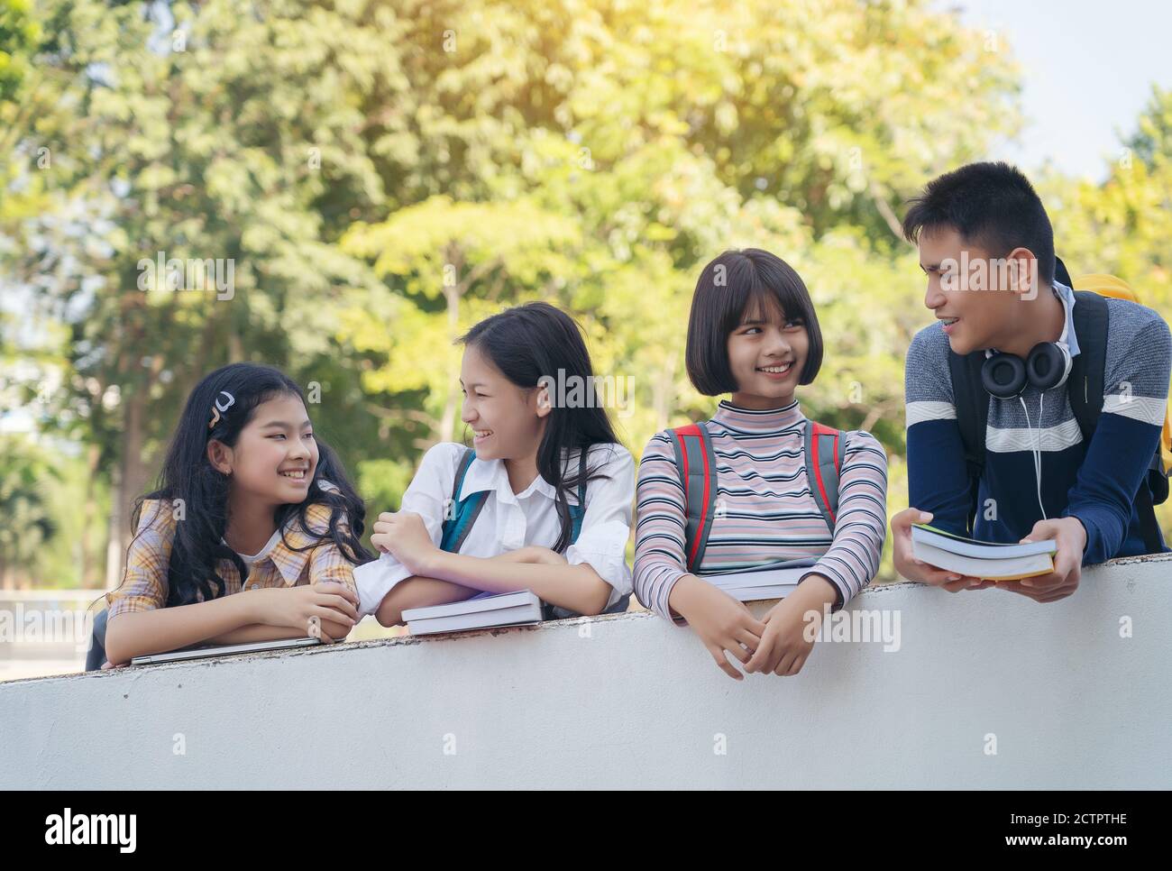 Group of students standing together over wall walkway Stock Photo - Alamy