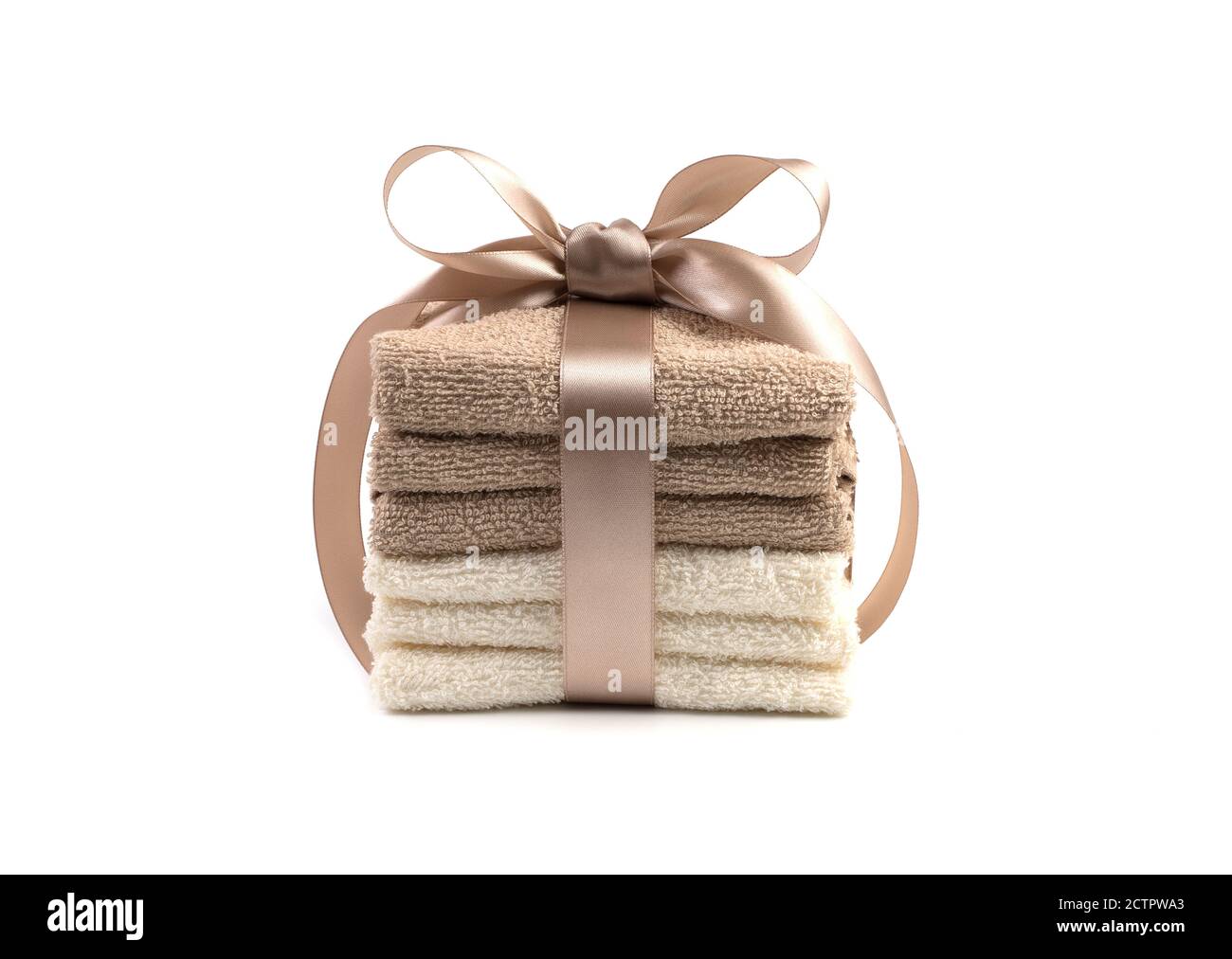 A stack of beige and white towels tied with a satin ribbon on a white ...