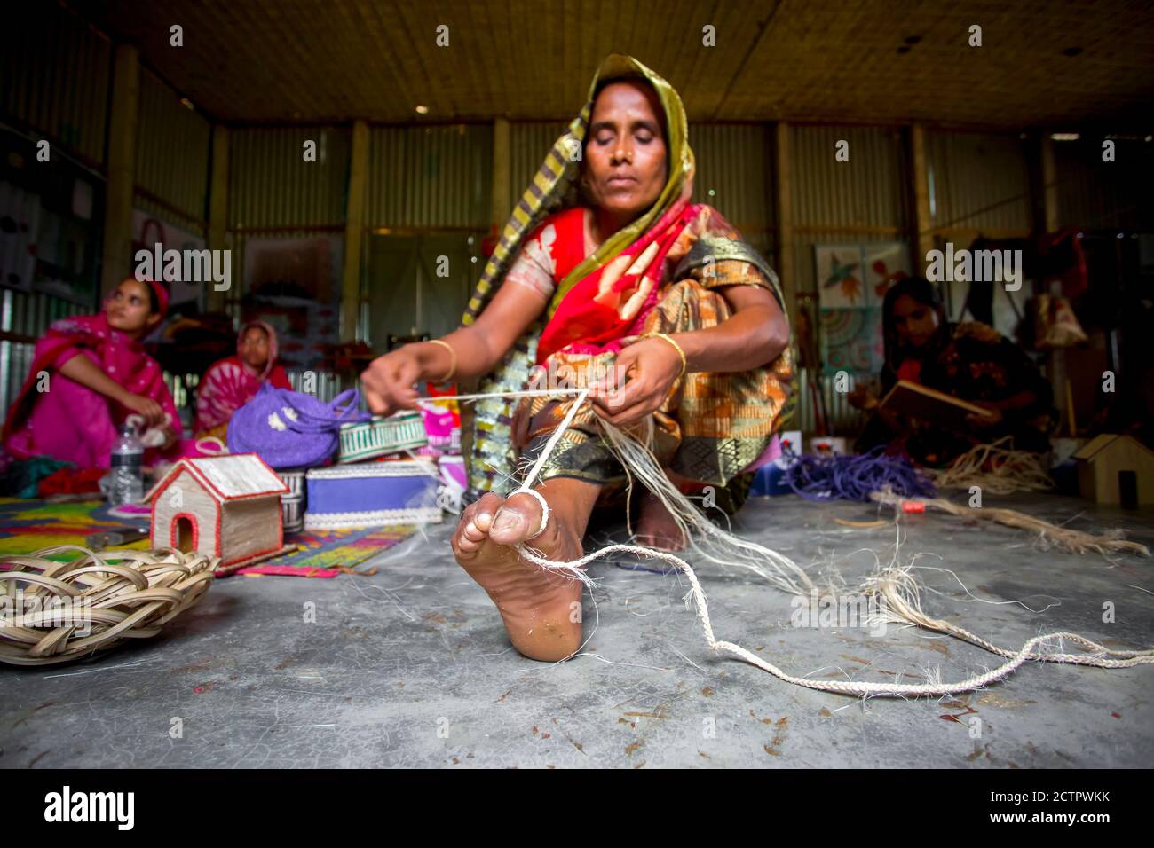 Bangladesh – May 13, 2018: An old woman is making a rope from the ...