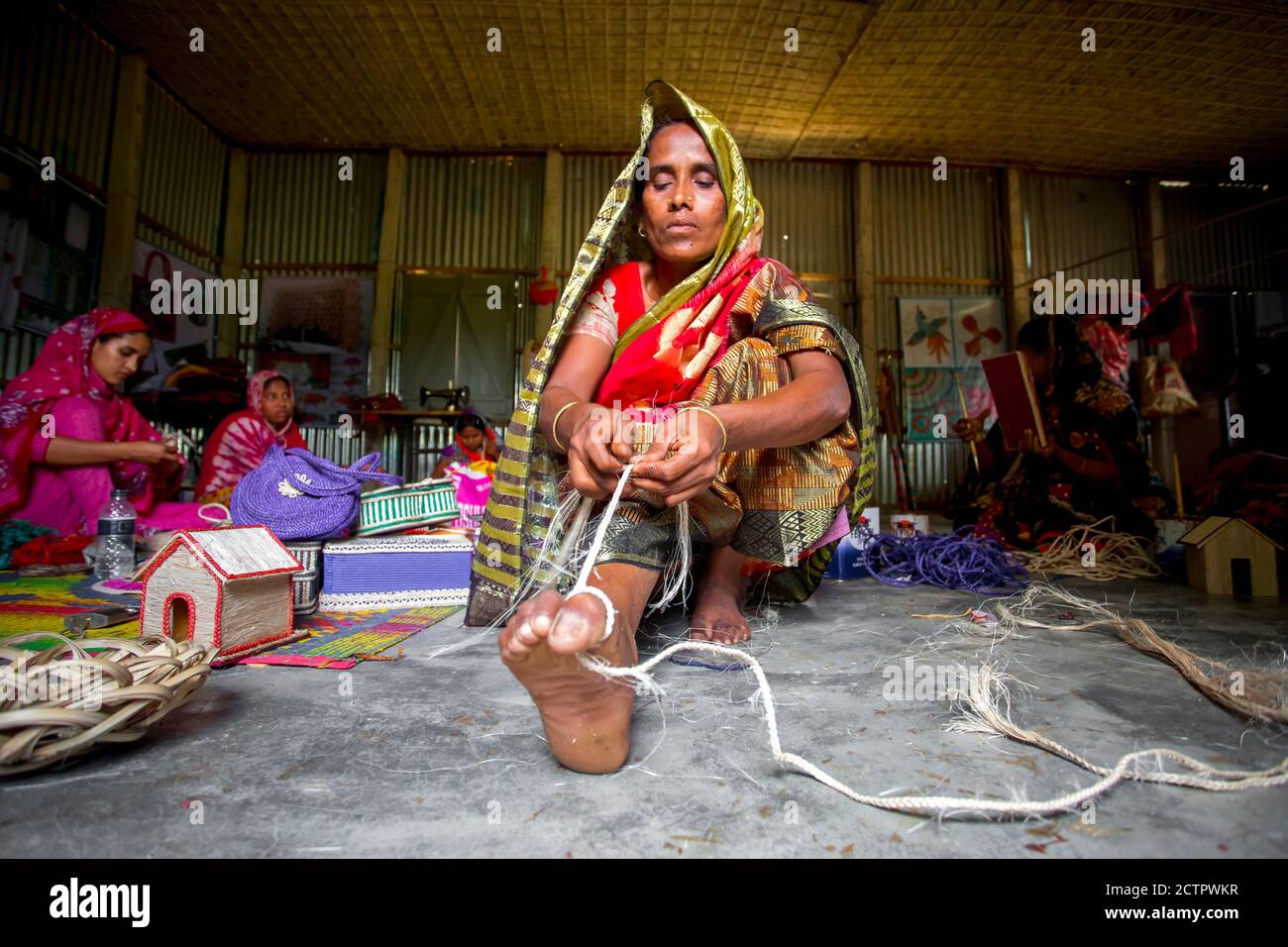 Bangladesh – May 13, 2018: An old woman is making a rope from the ...