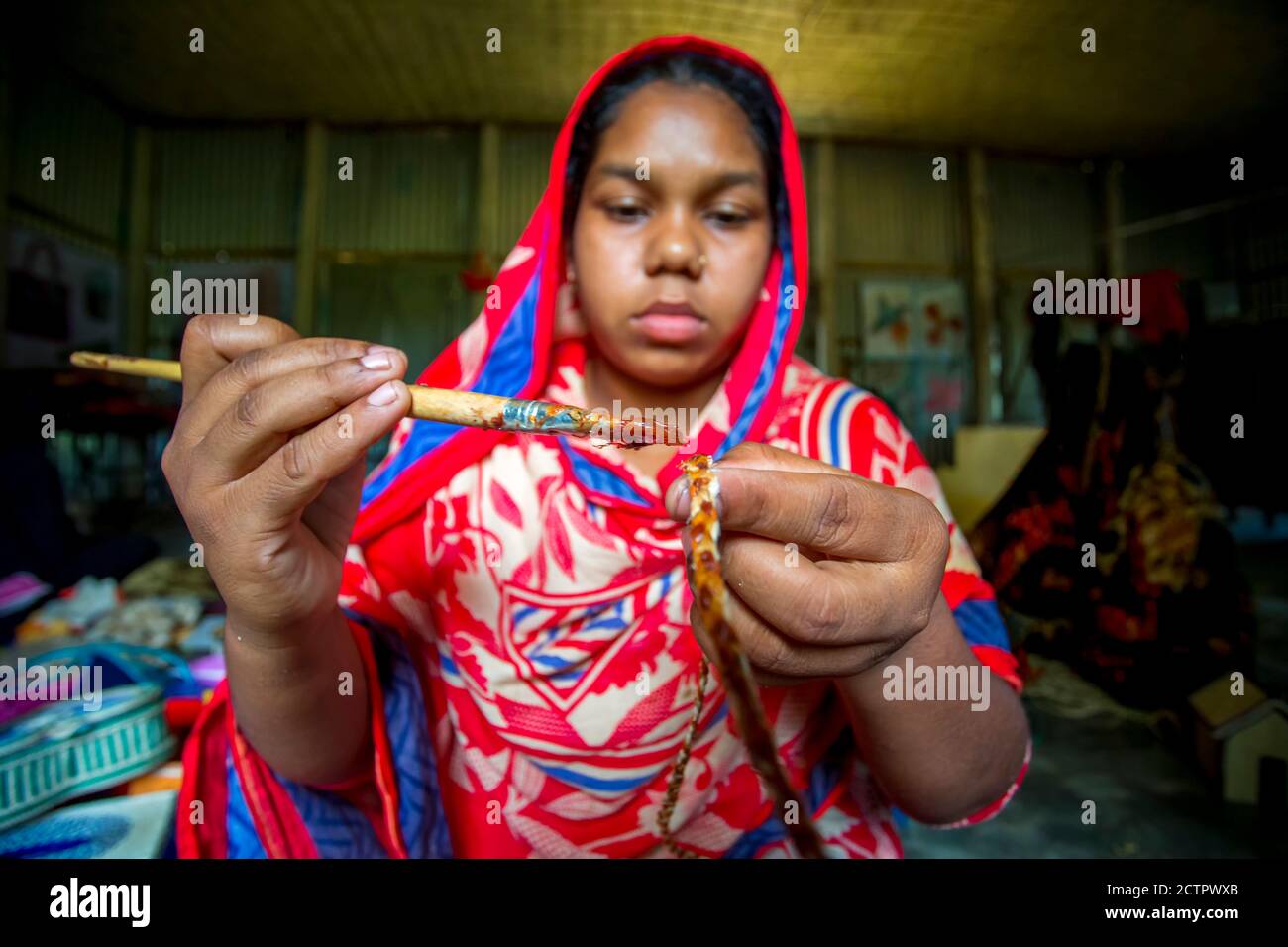 A young crafts maker is making a showpiece from the fibers of a banana tree at Madhupur, Tangail ...