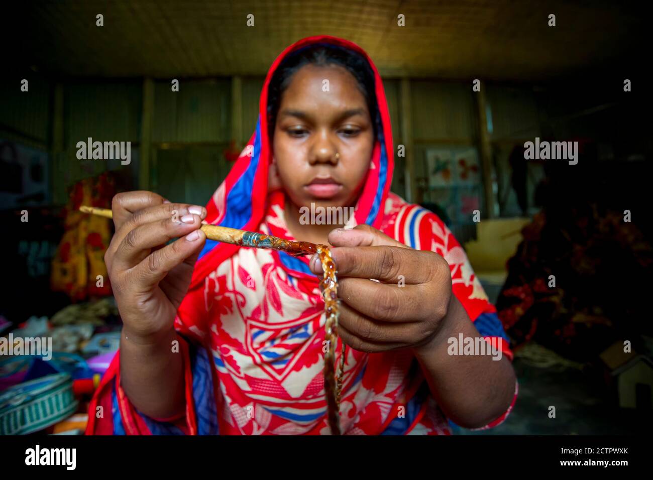 A young crafts maker is making a showpiece from the fibers of a banana tree at Madhupur, Tangail ...