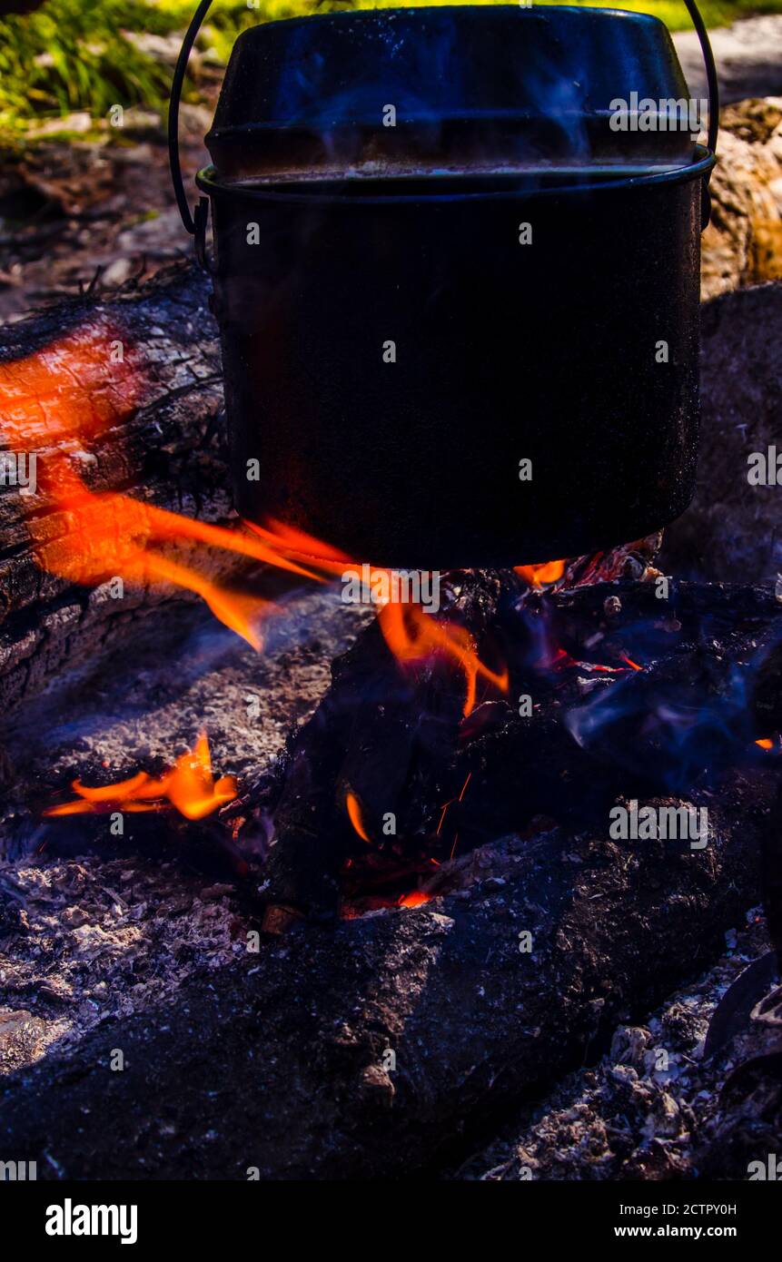 fire burns in the campaign. pot of tea by the fire Stock Photo - Alamy