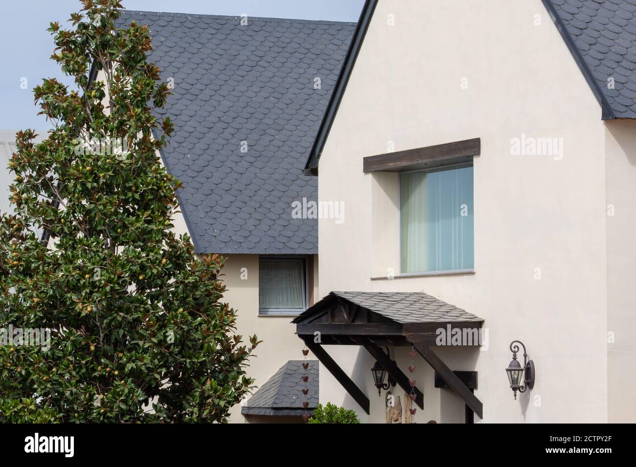 Exterior view of a slate roof residential house with a large magnolia ...