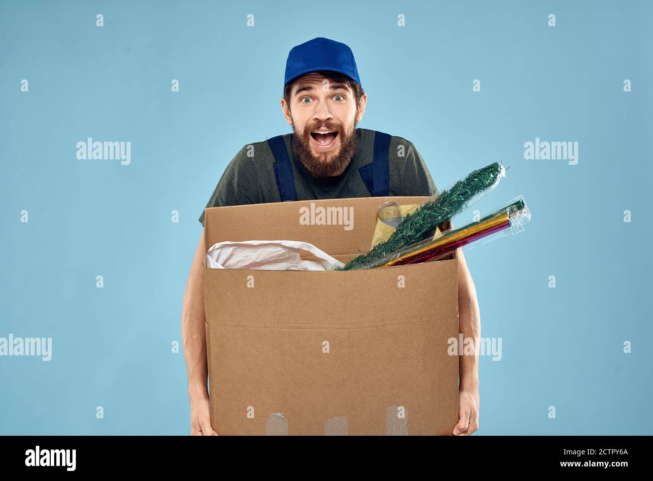 A man in working uniform with boxes in the hands of a carriage delivery ...