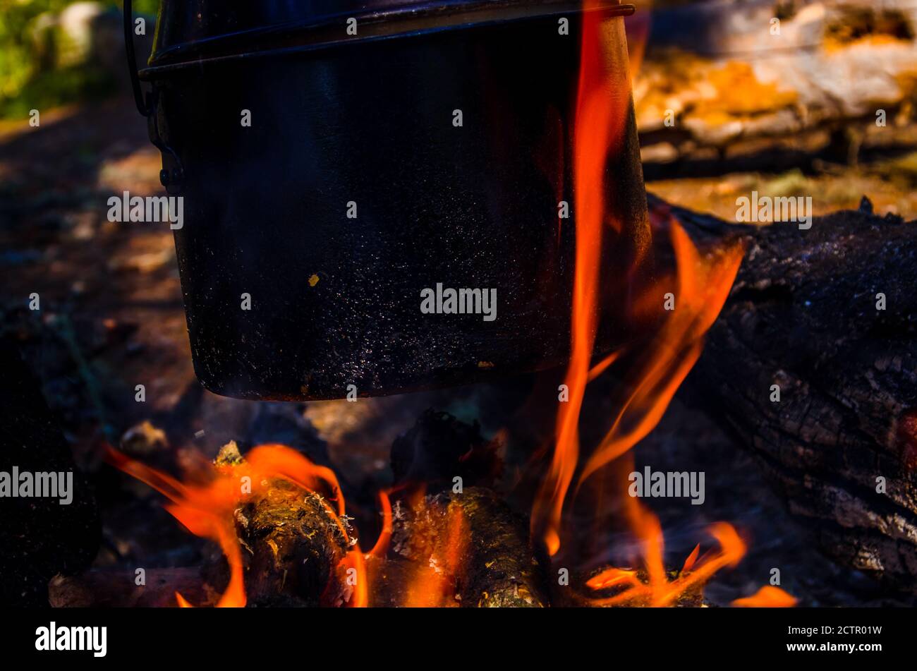 fire burns in the campaign. pot of tea by the fire Stock Photo - Alamy