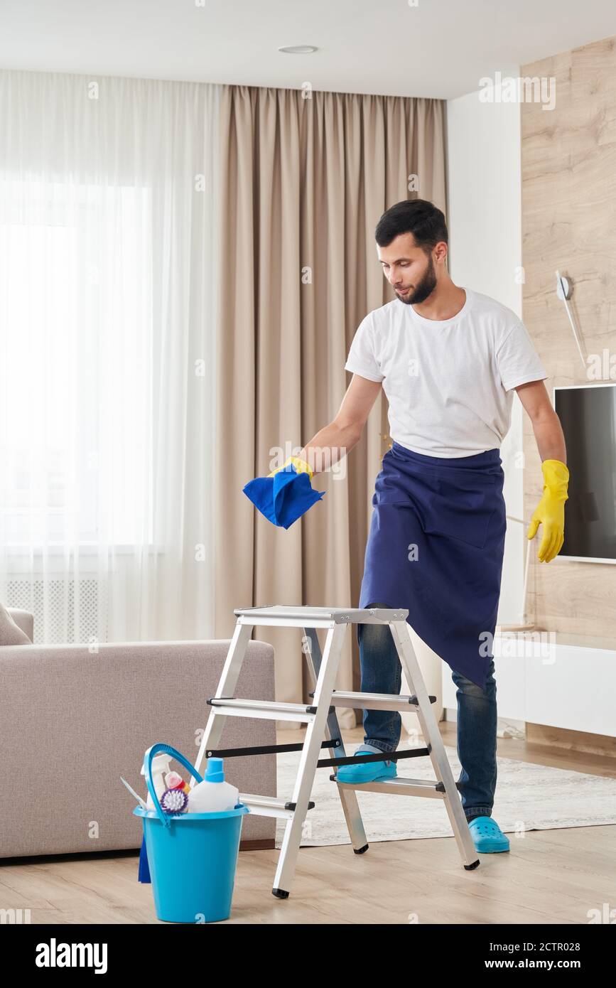 Man climbing ladder to clean ceiling. Cleaning service concept Stock ...