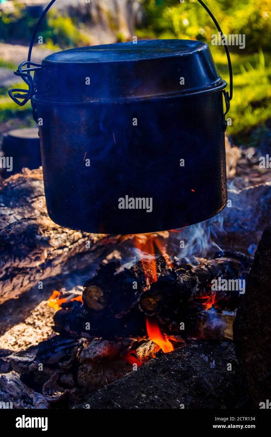 fire burns in the campaign. pot of tea by the fire Stock Photo - Alamy
