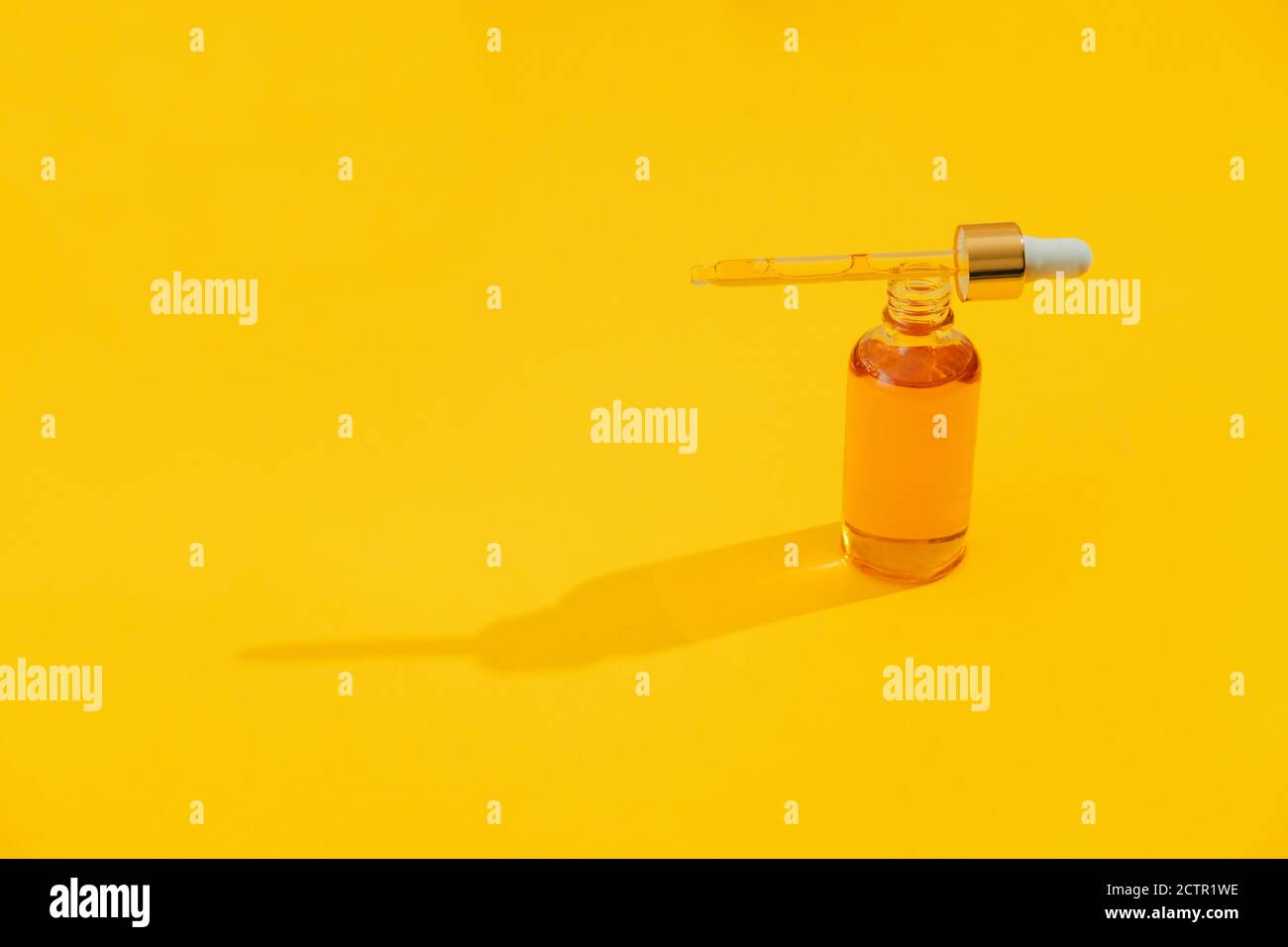 Orange color serum bottles on bright illuminating yellow background ...