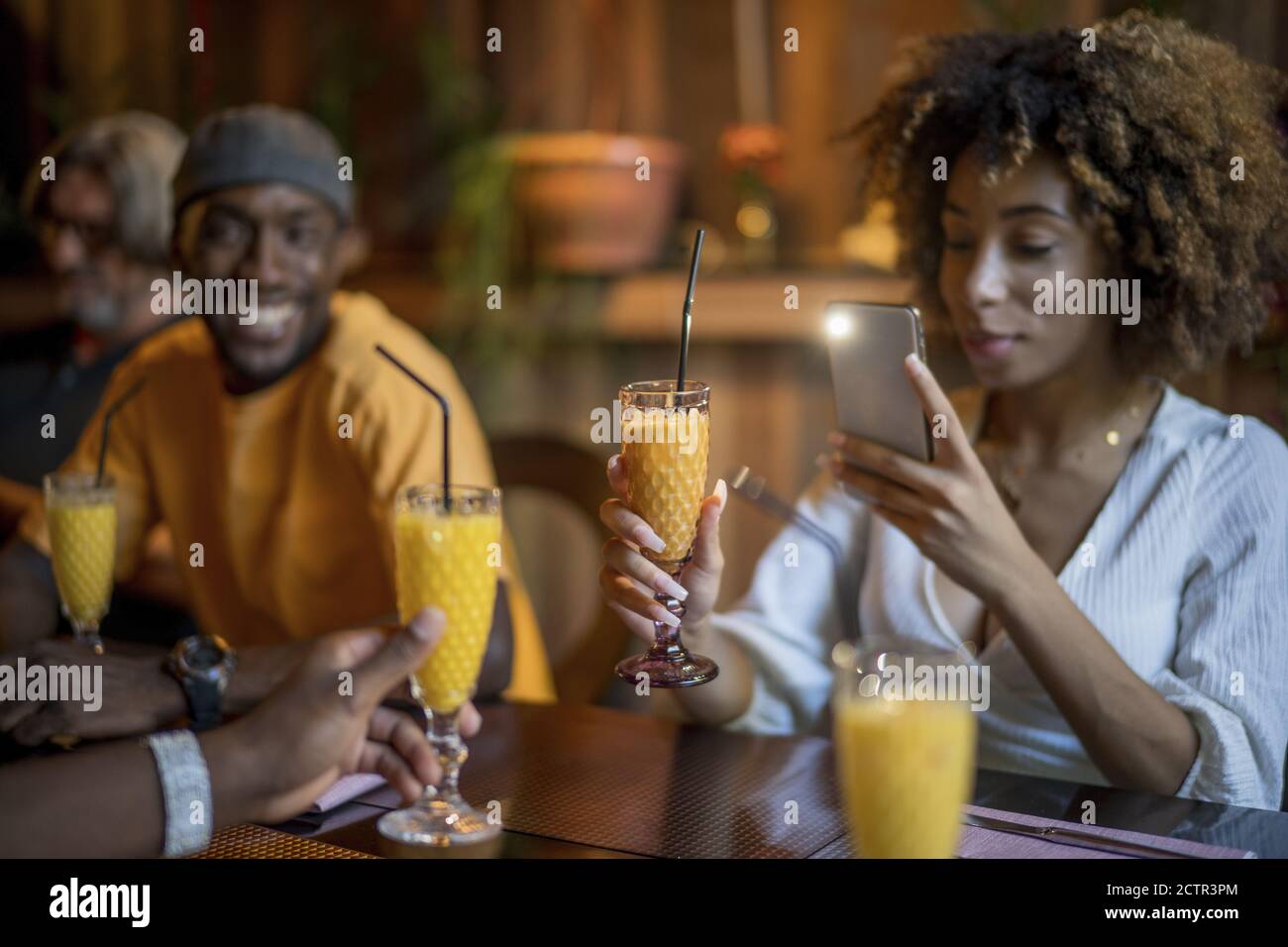 Group of multiethnic friends drinking cocktails and having a fun time ...