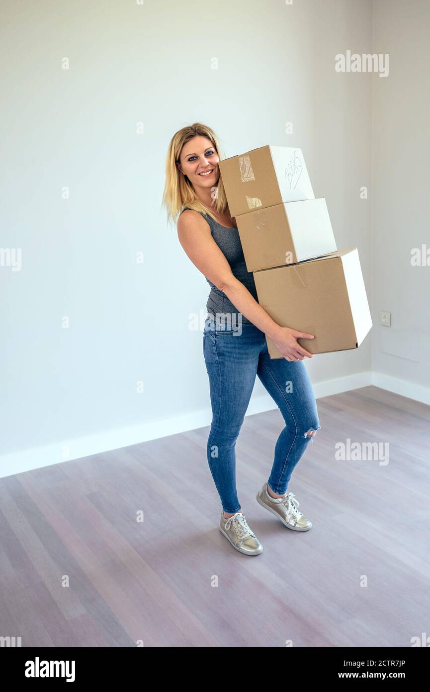 Woman carrying moving boxes Stock Photo - Alamy