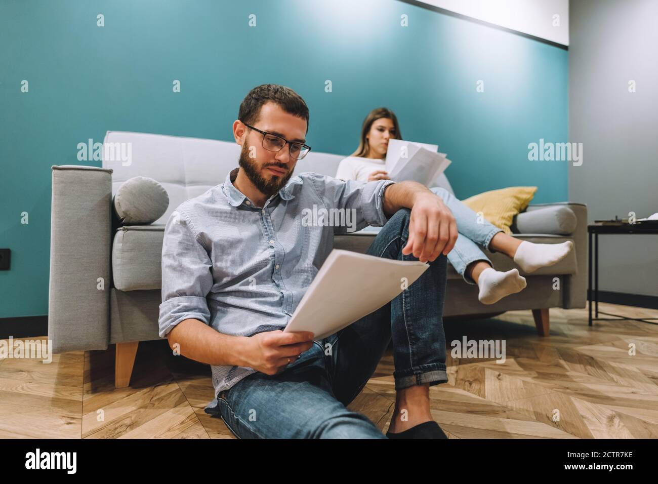 A young couple manages finances by looking through their bank accounts ...