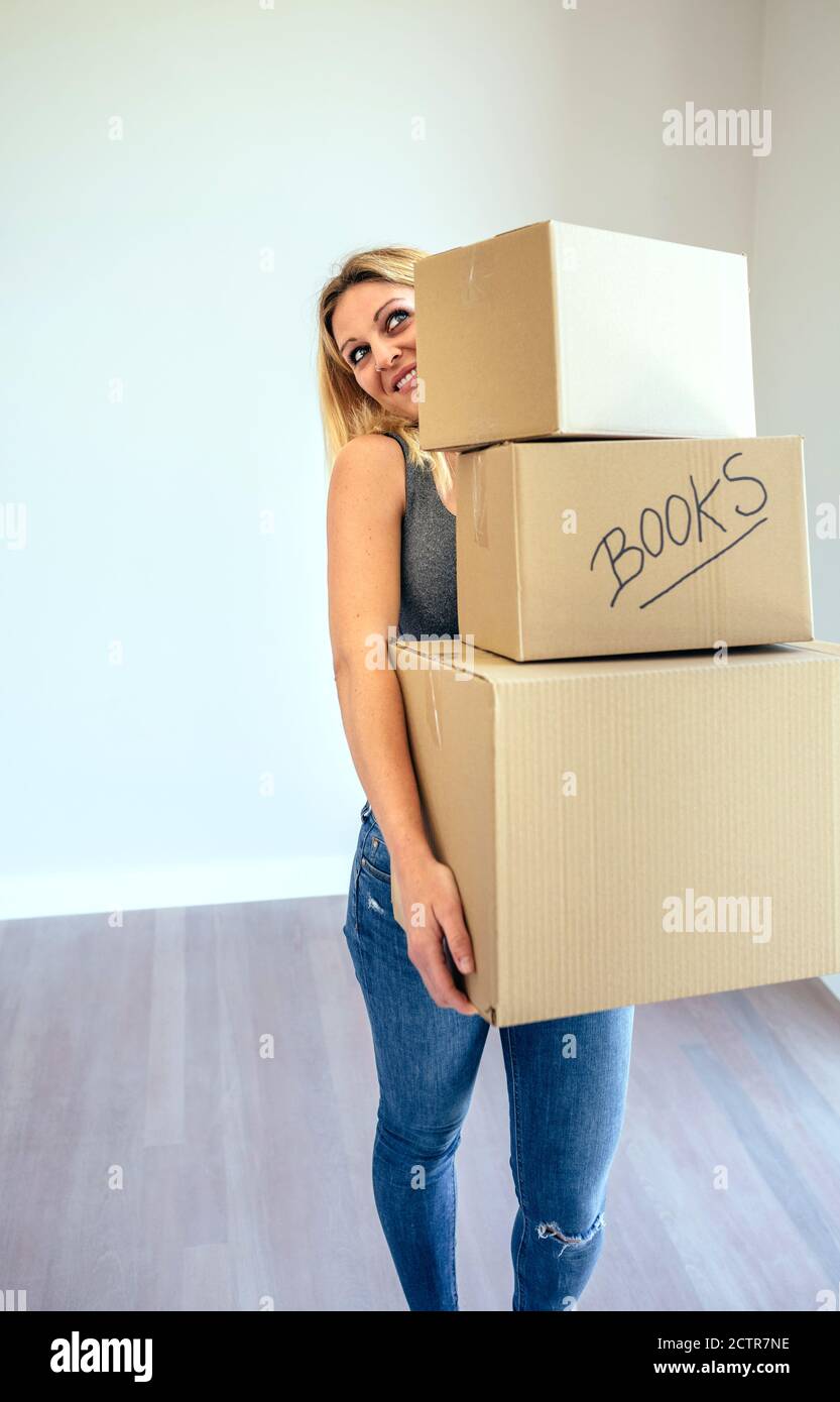 Woman carrying moving boxes Stock Photo - Alamy