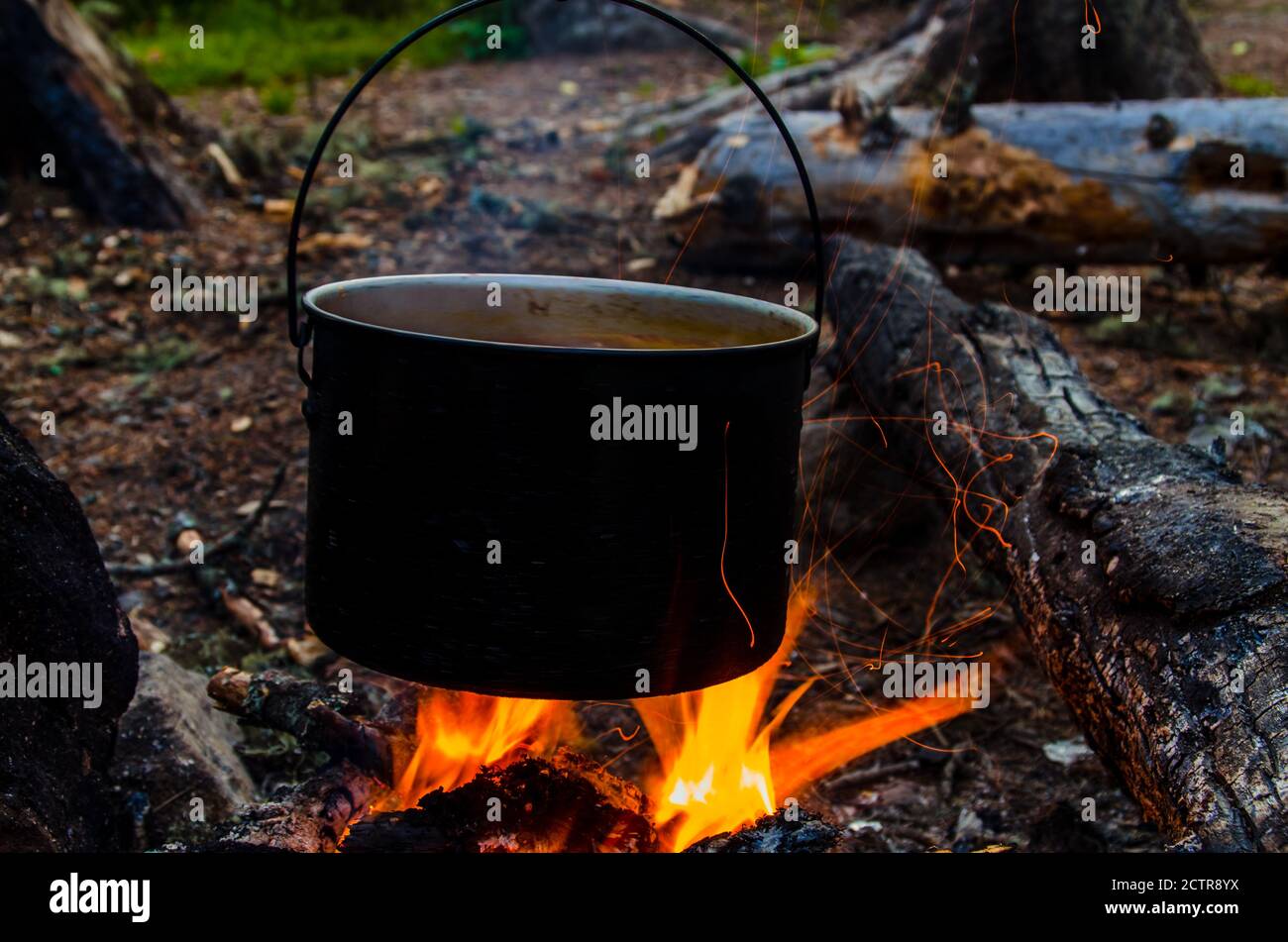 fire burns in the campaign. pot of tea by the fire Stock Photo - Alamy
