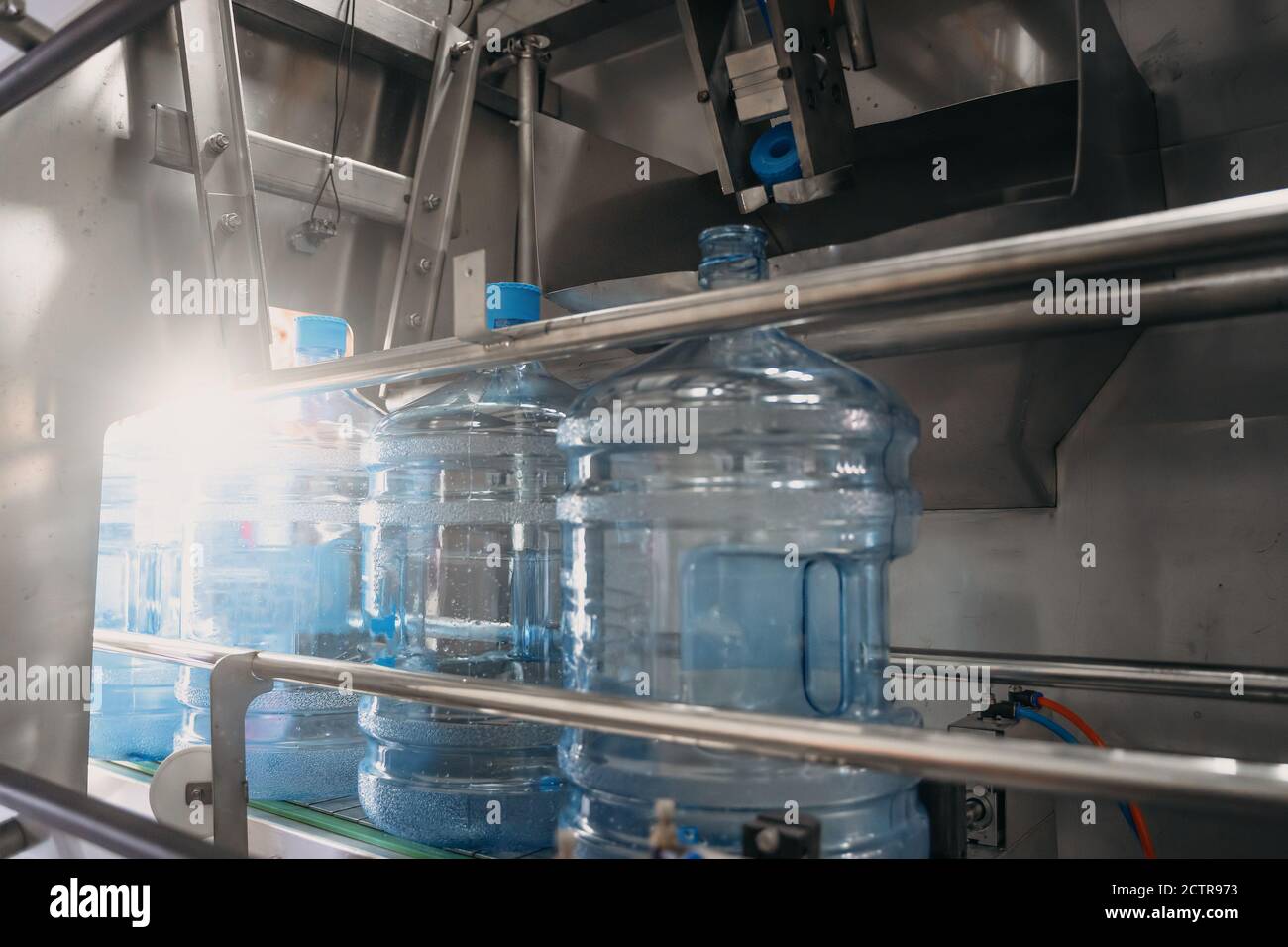 Plastic bottles or gallons on automated conveyor production line. Water ...