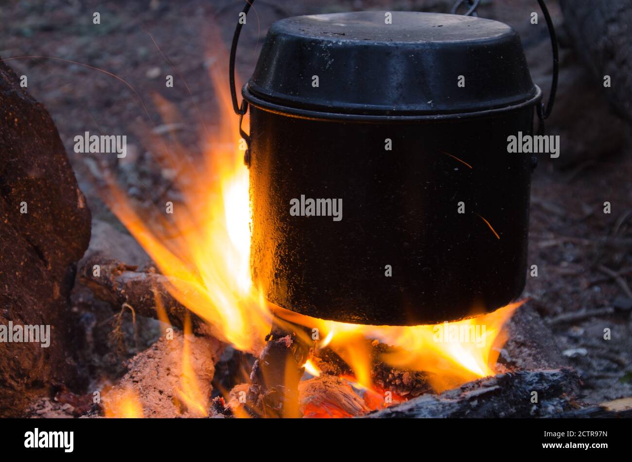 fire burns in the campaign. pot of tea by the fire Stock Photo - Alamy