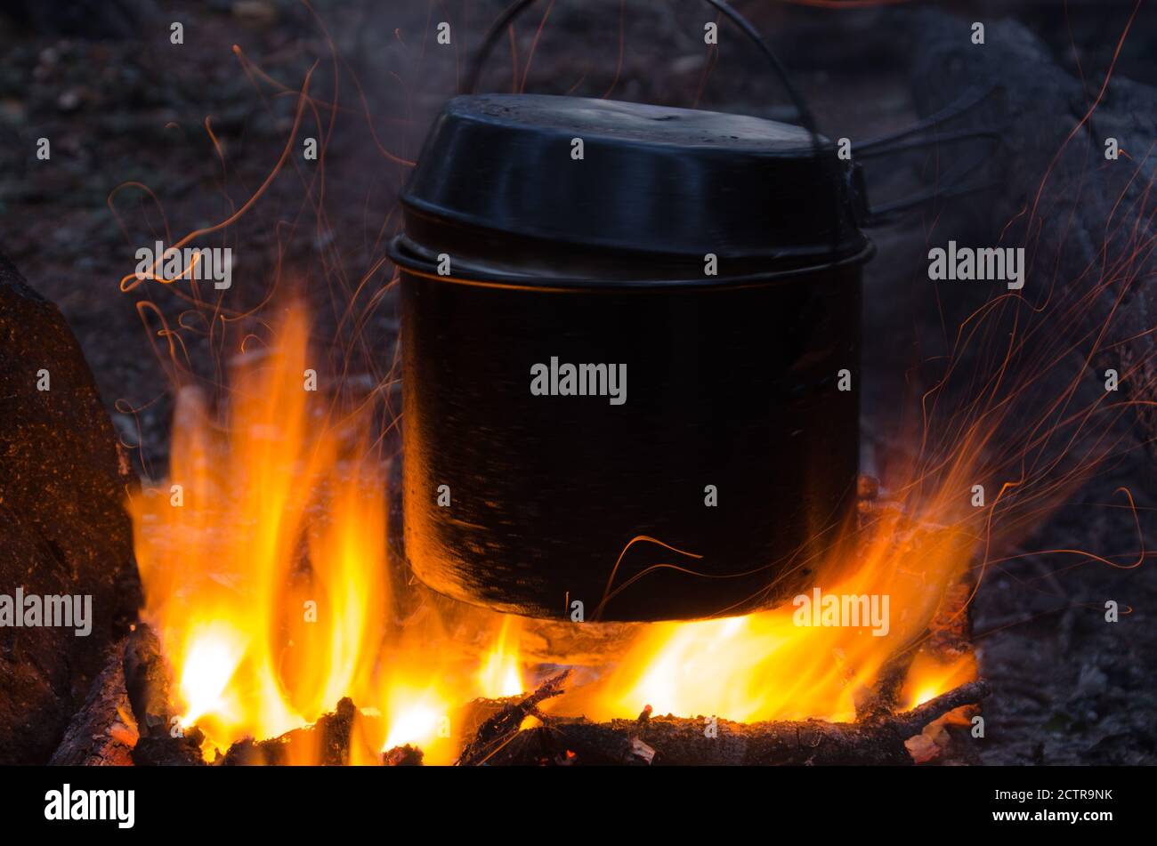fire burns in the campaign. pot of tea by the fire Stock Photo - Alamy