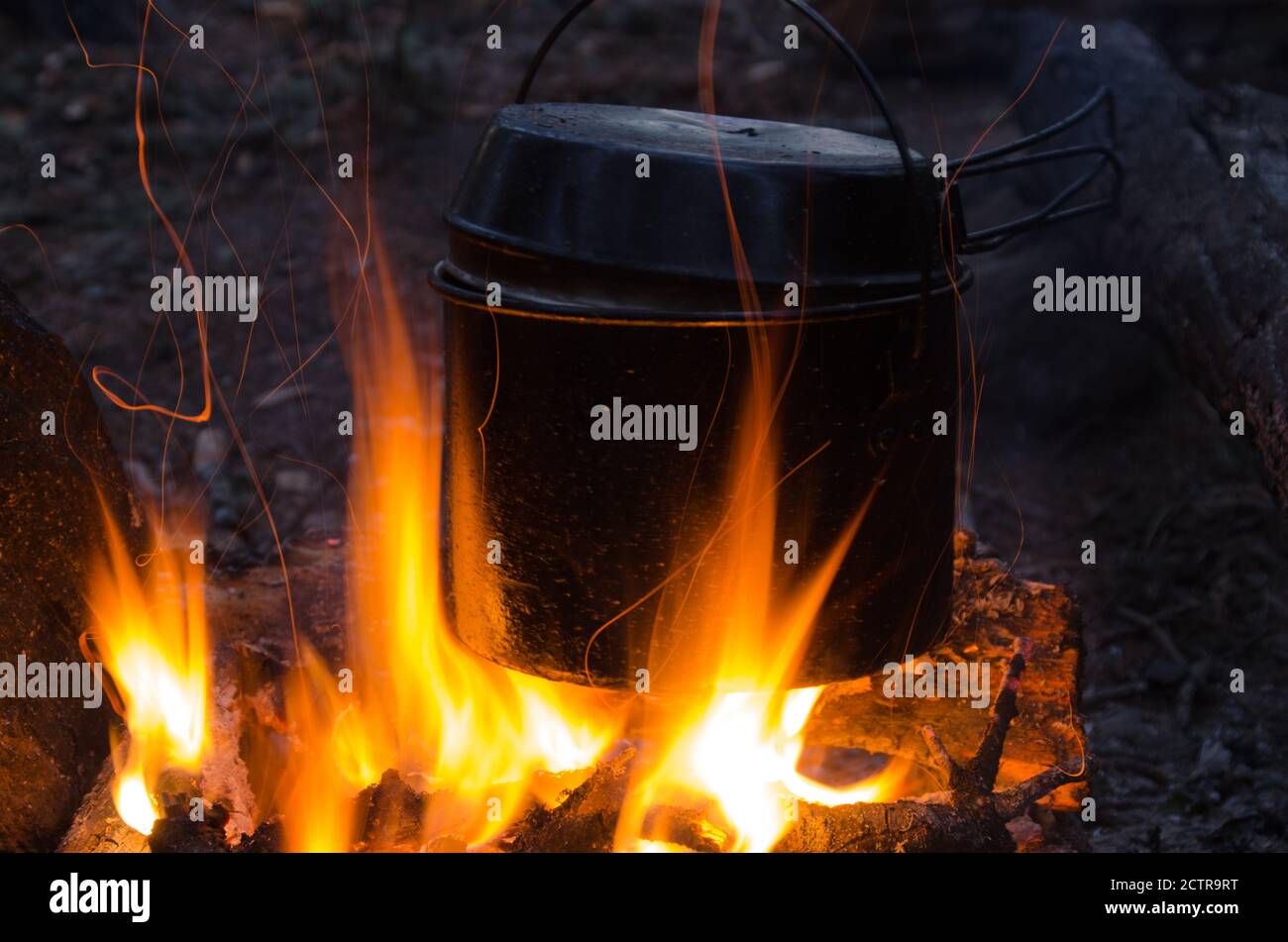 fire burns in the campaign. pot of tea by the fire Stock Photo - Alamy