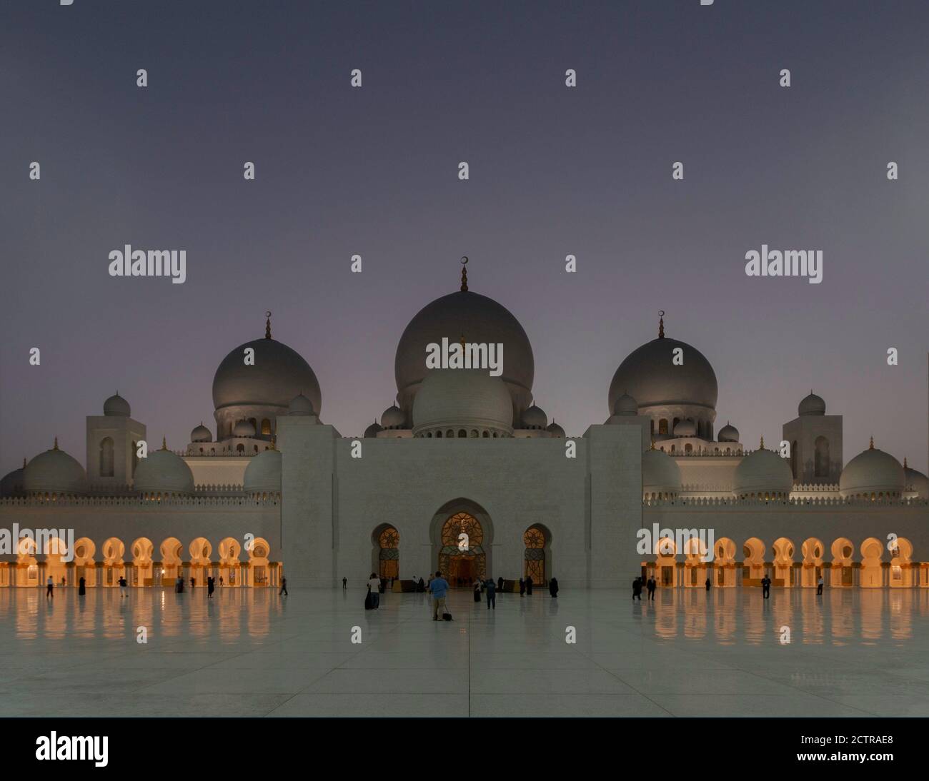 The domes of the Sheikh Zayed Grand Mosque as the sun is setting over ...