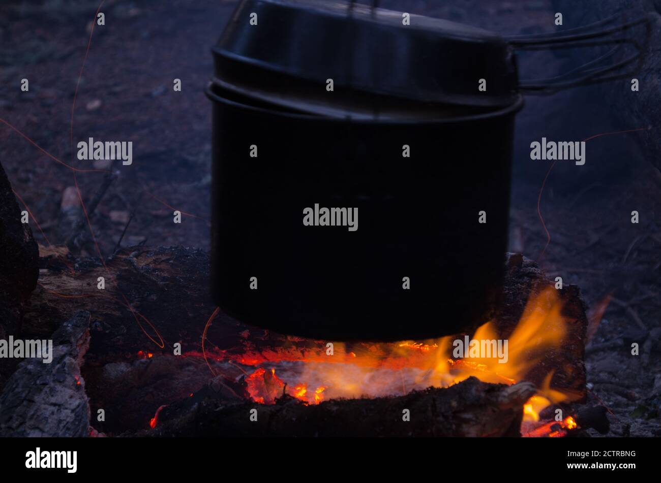 fire burns in the campaign. pot of tea by the fire Stock Photo - Alamy