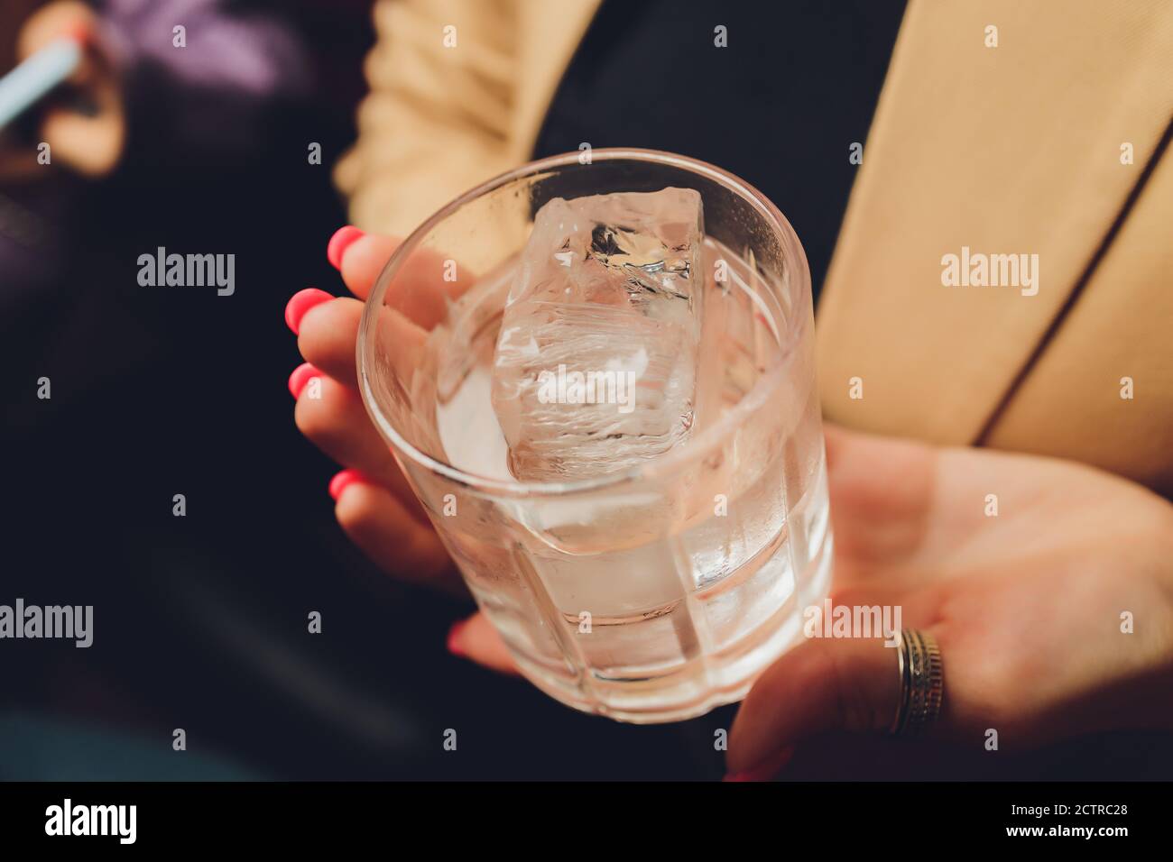 Female hands holding a clear glass of water. Slime body on background ...