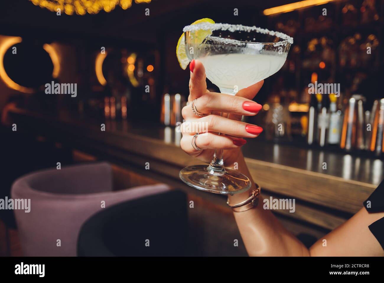 Female hands holding a clear glass of water. Slime body on background ...