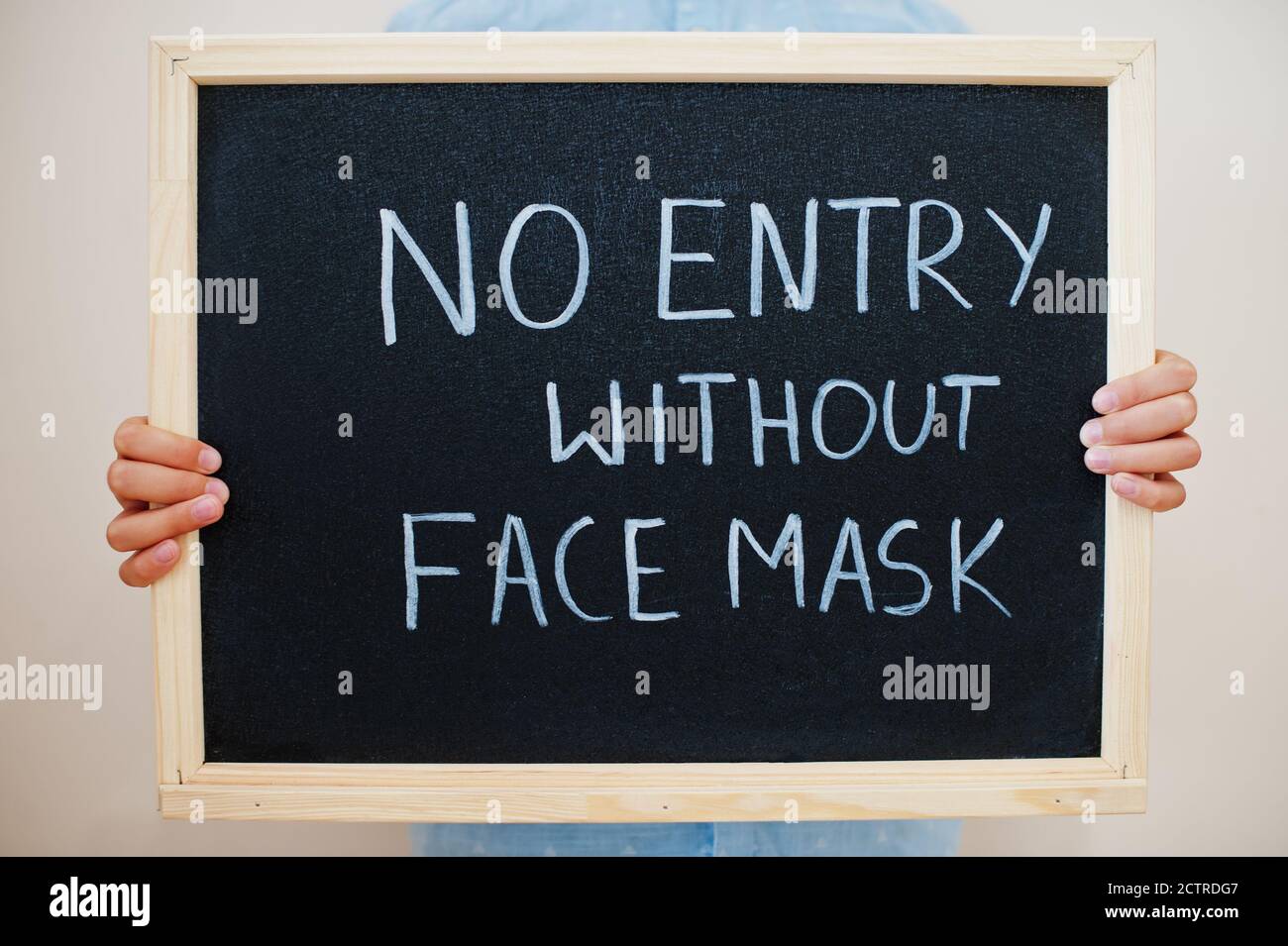 No entry without face mask. Coronavirus concept. Boy hold inscription ...